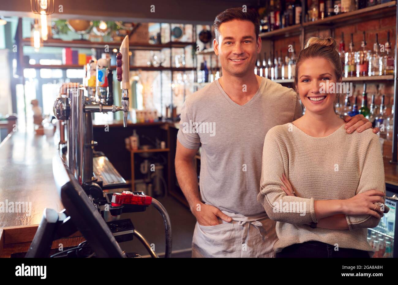 Portrait Of Smiling Couple Owning Bar Standing Behind Counter Stock ...