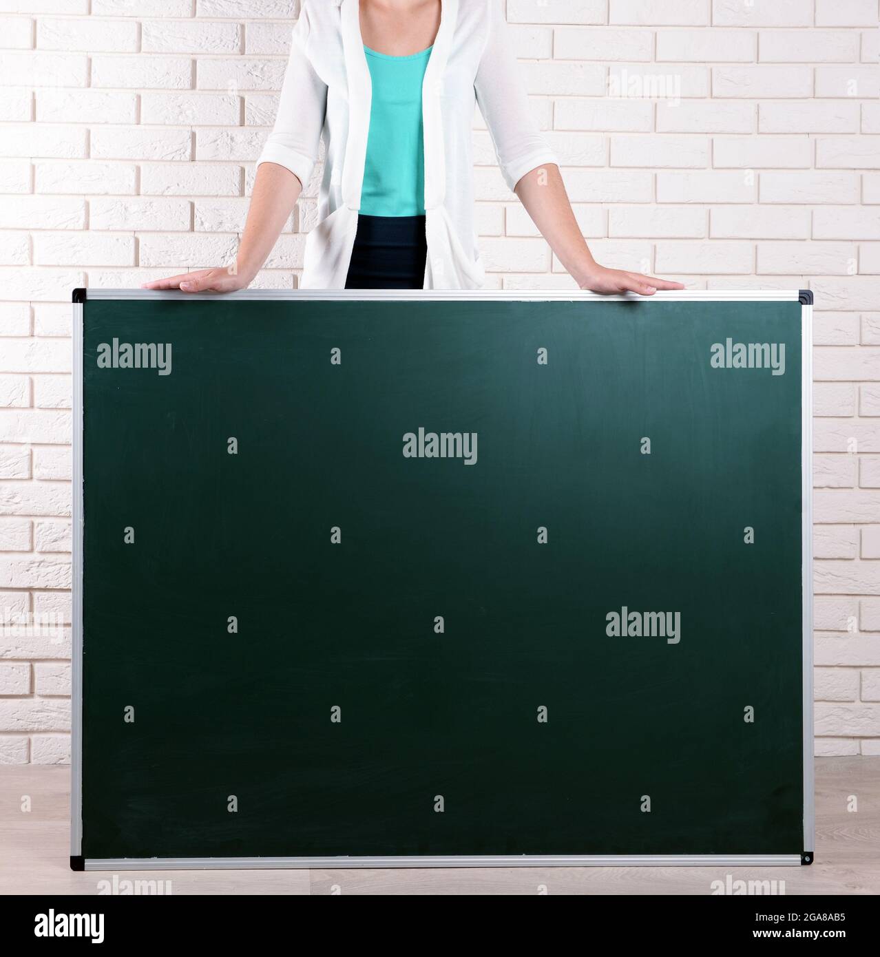 Teacher with blackboard in classroom Stock Photo - Alamy