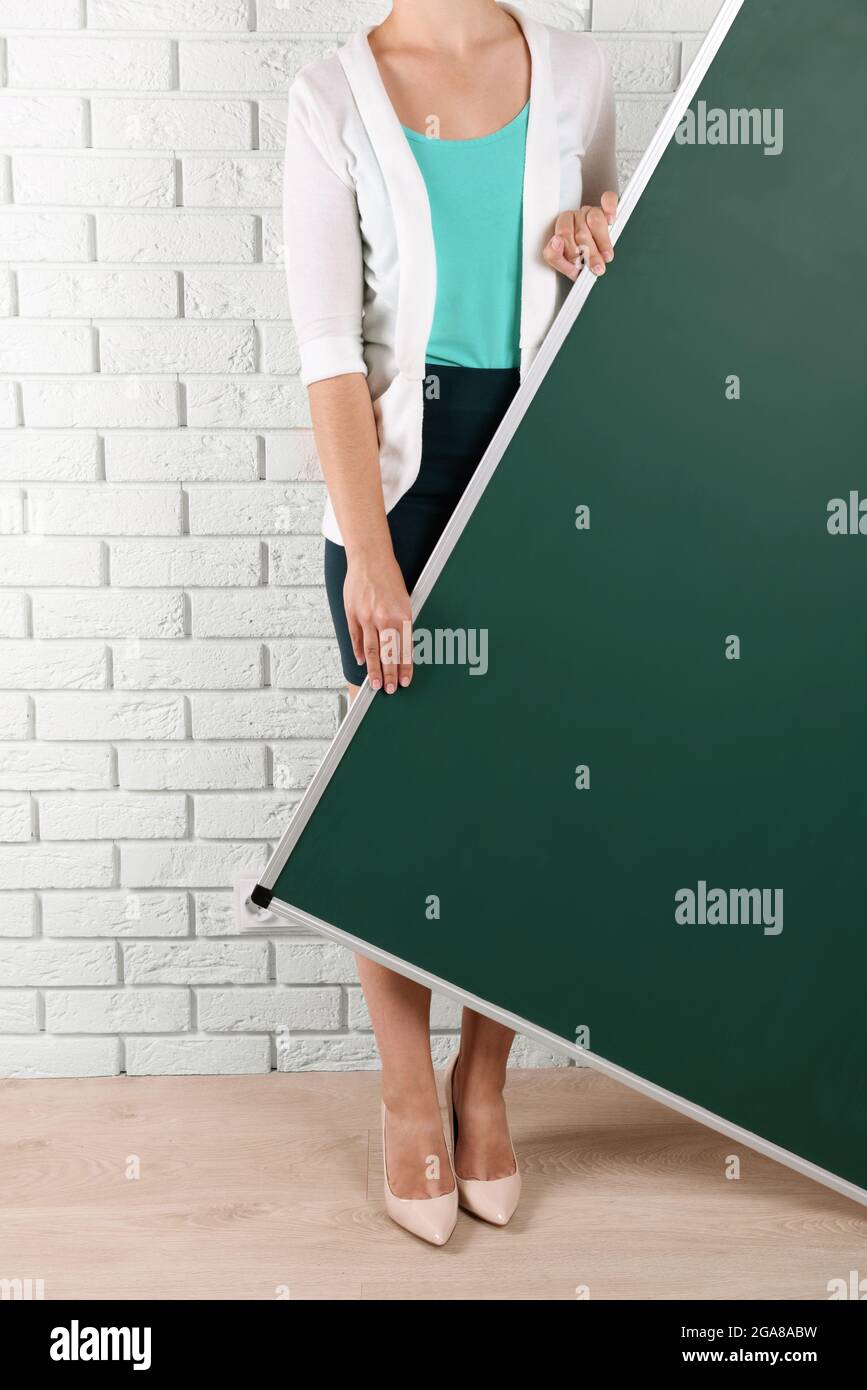 Teacher with blackboard in classroom Stock Photo - Alamy