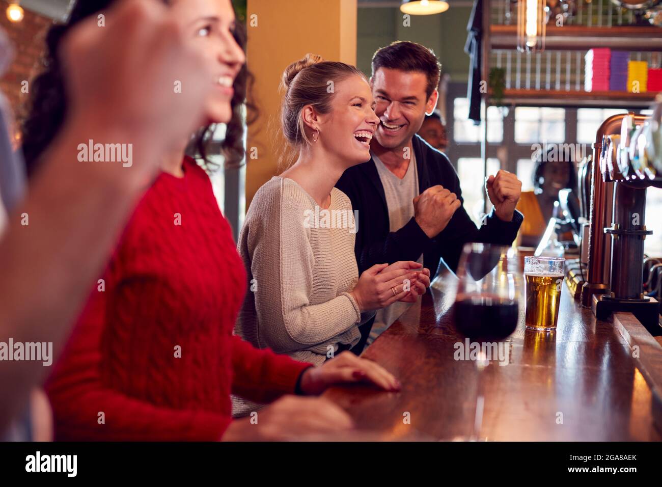 Group Of Excited Customers In Sports Bar Watching Sporting Event On ...