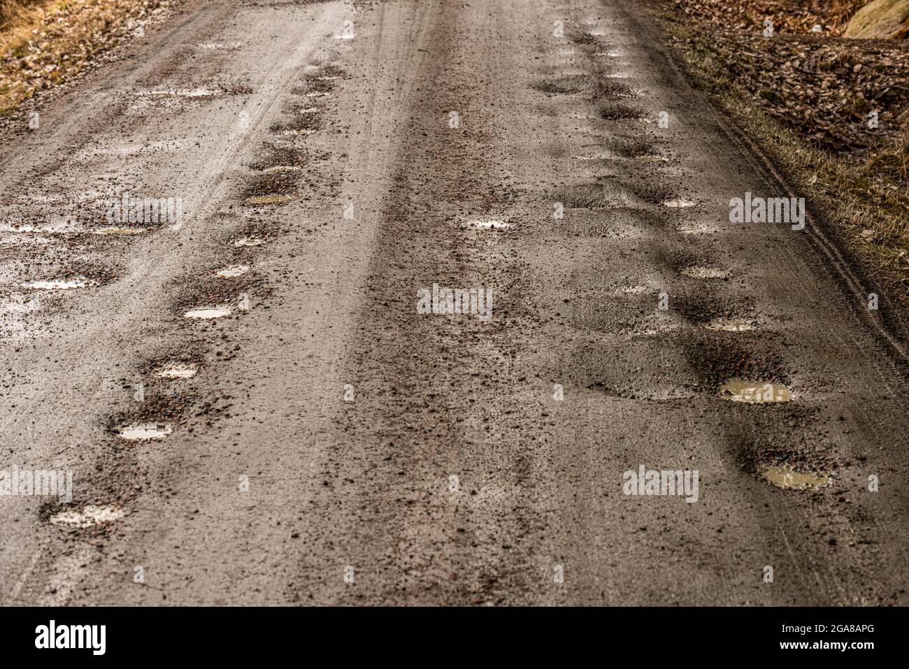 A row of potholes making the gravel road uncomfortable to drive on ...