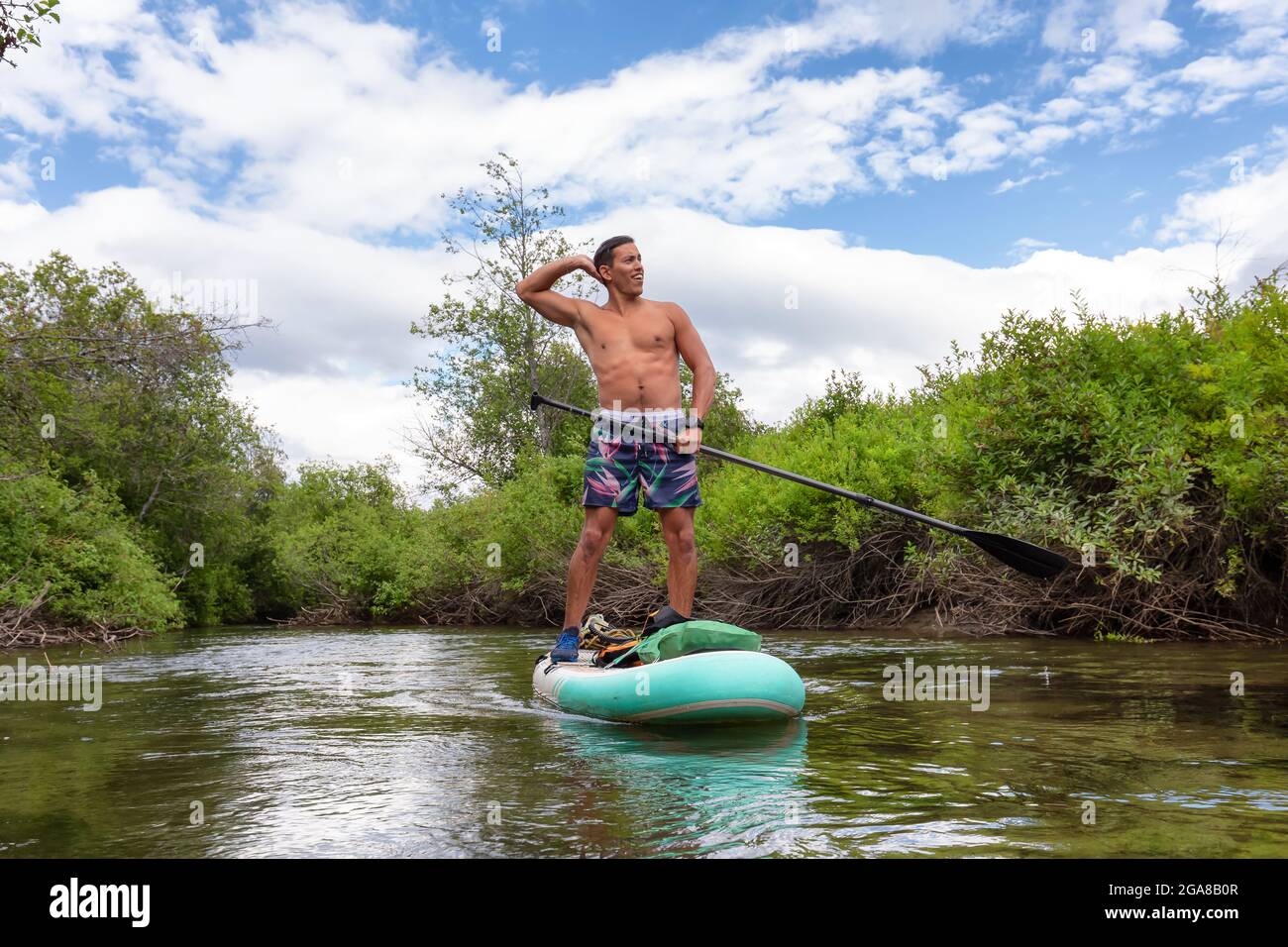 Adventurous Hispanic Adult Athletic Man paddle boarding Stock Photo - Alamy