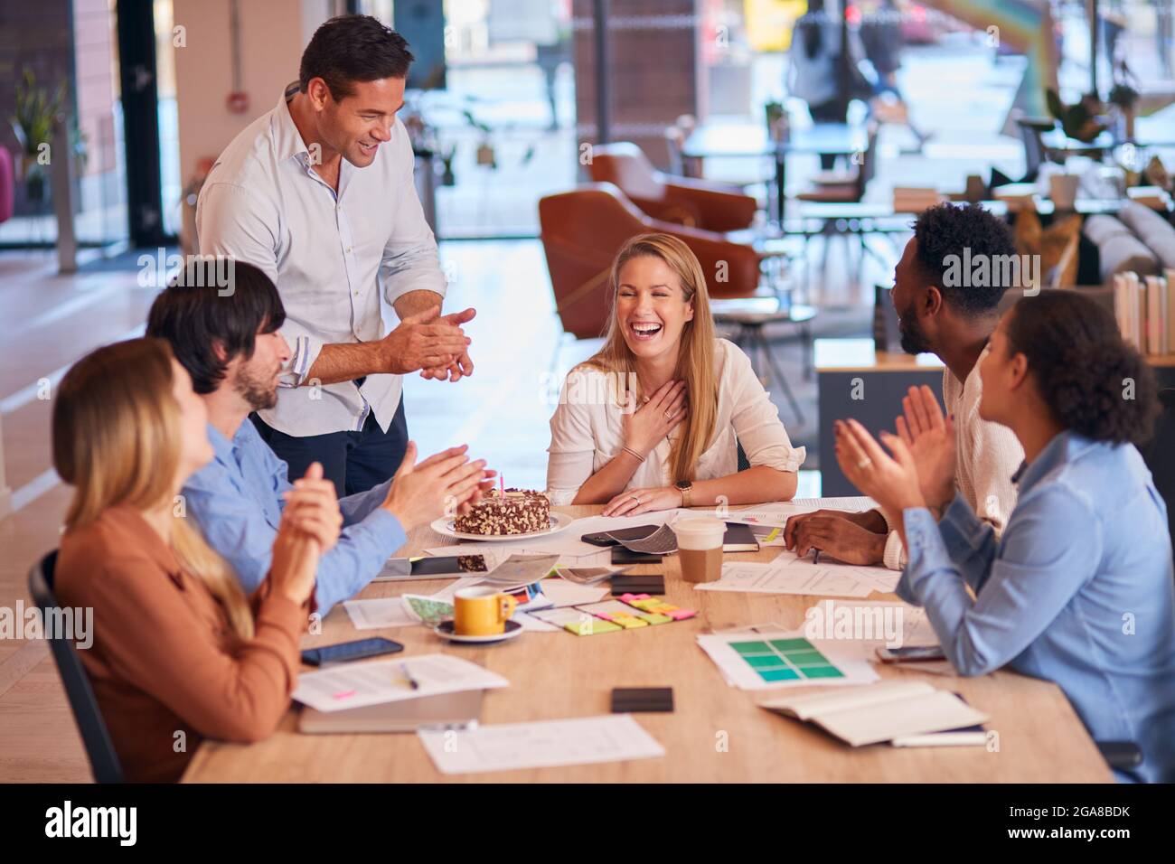 Colleagues Celebrating Businesswoman's Birthday At Meeting Around Table ...