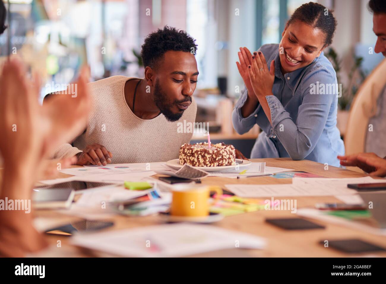 Colleagues Celebrating Businessman's Birthday At Meeting Around Table ...