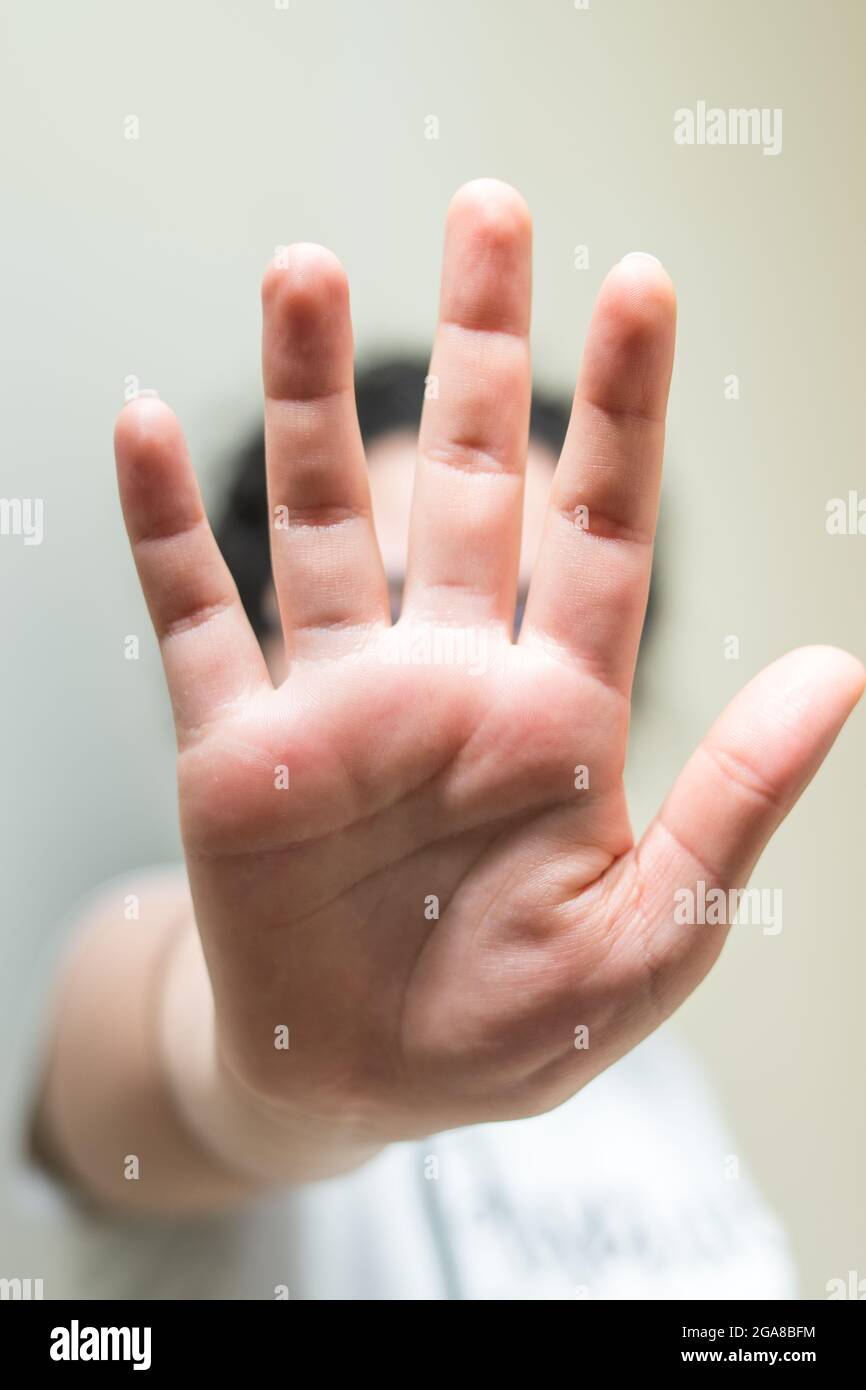 Caucasian woman raising the hand showing her palm on a white background ...