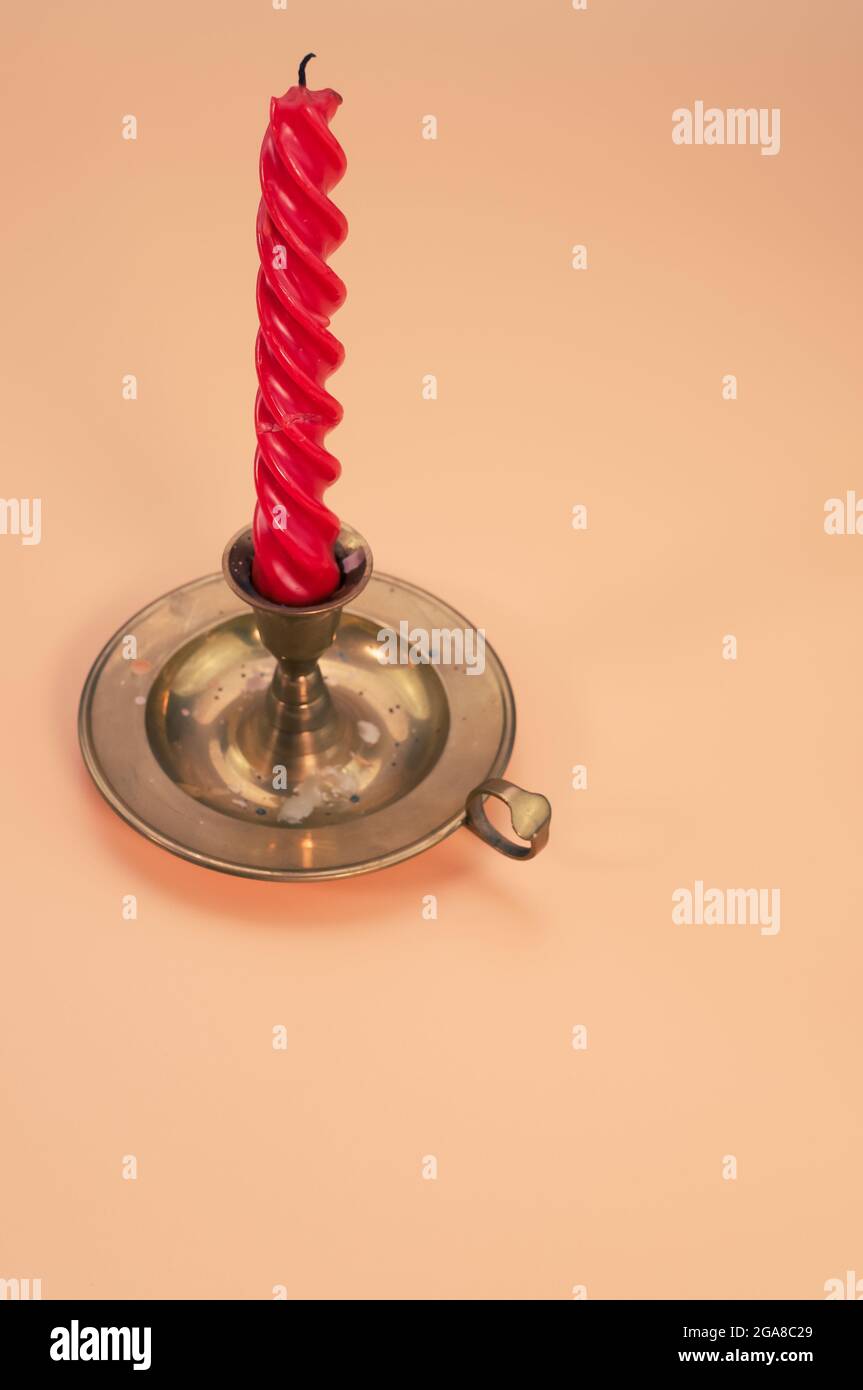 Red candlestick with a metal holder isolated on a beige background ...