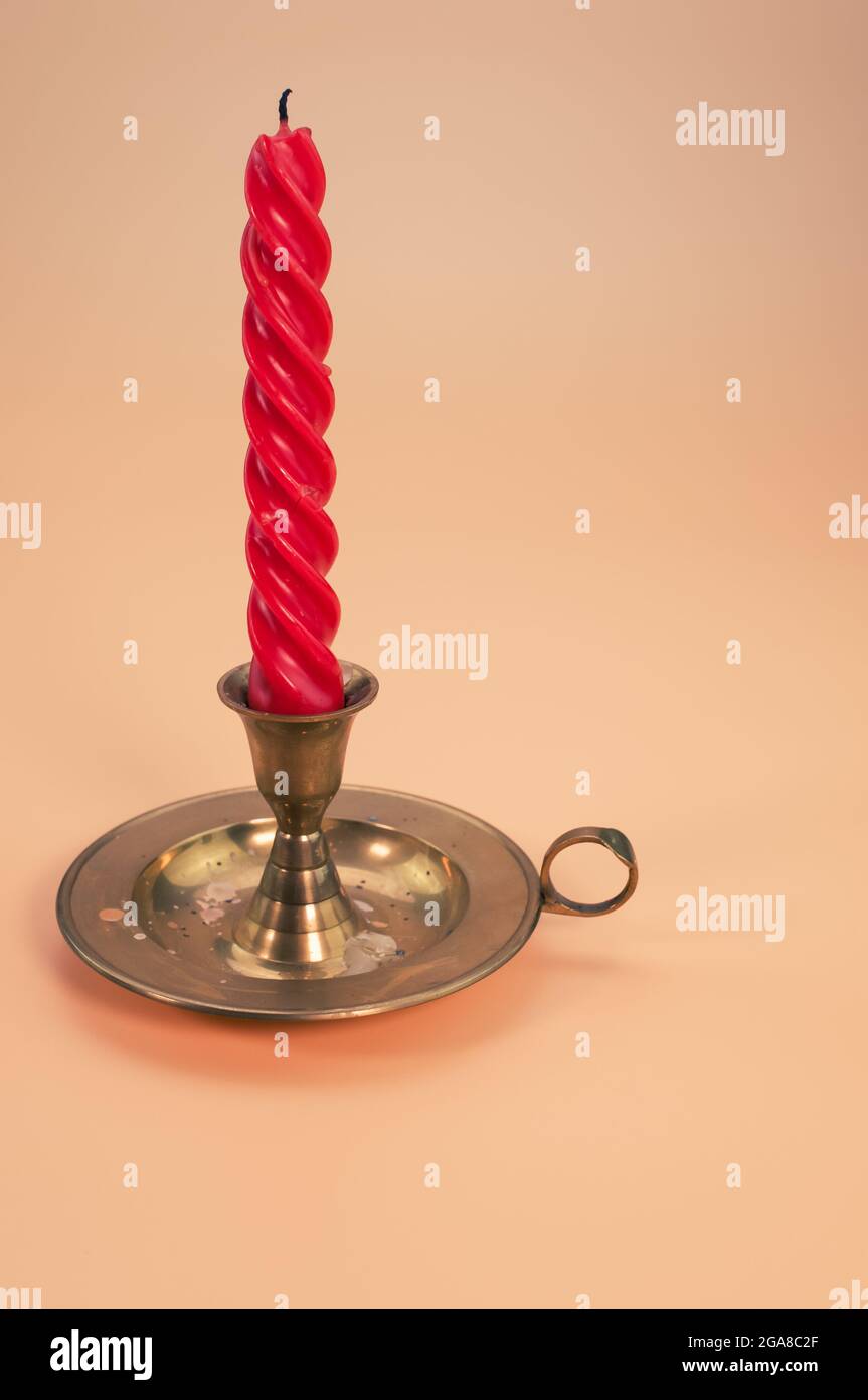 Red candlestick with a metal holder isolated on a beige background ...