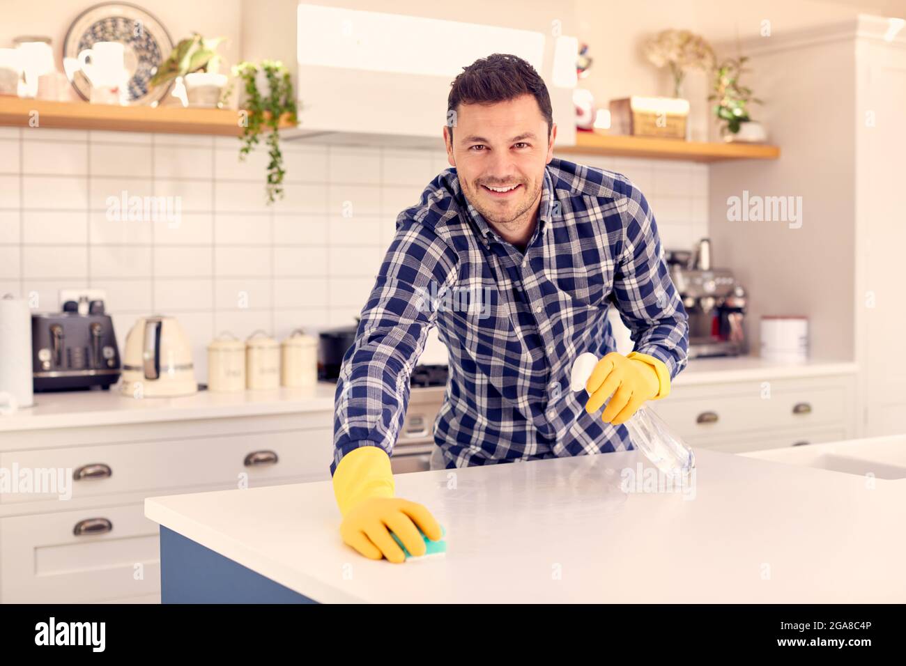 Portrait Of Man At Home In Kitchen Doing Housework And Cleaning Counter ...