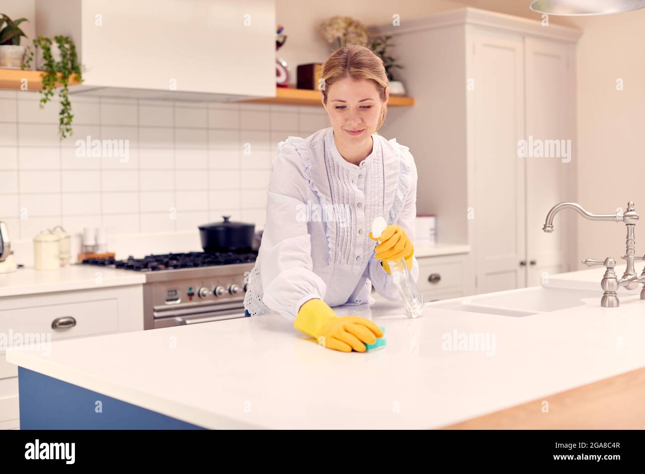 Woman At Home In Kitchen Doing Housework And Cleaning Counter Surface ...