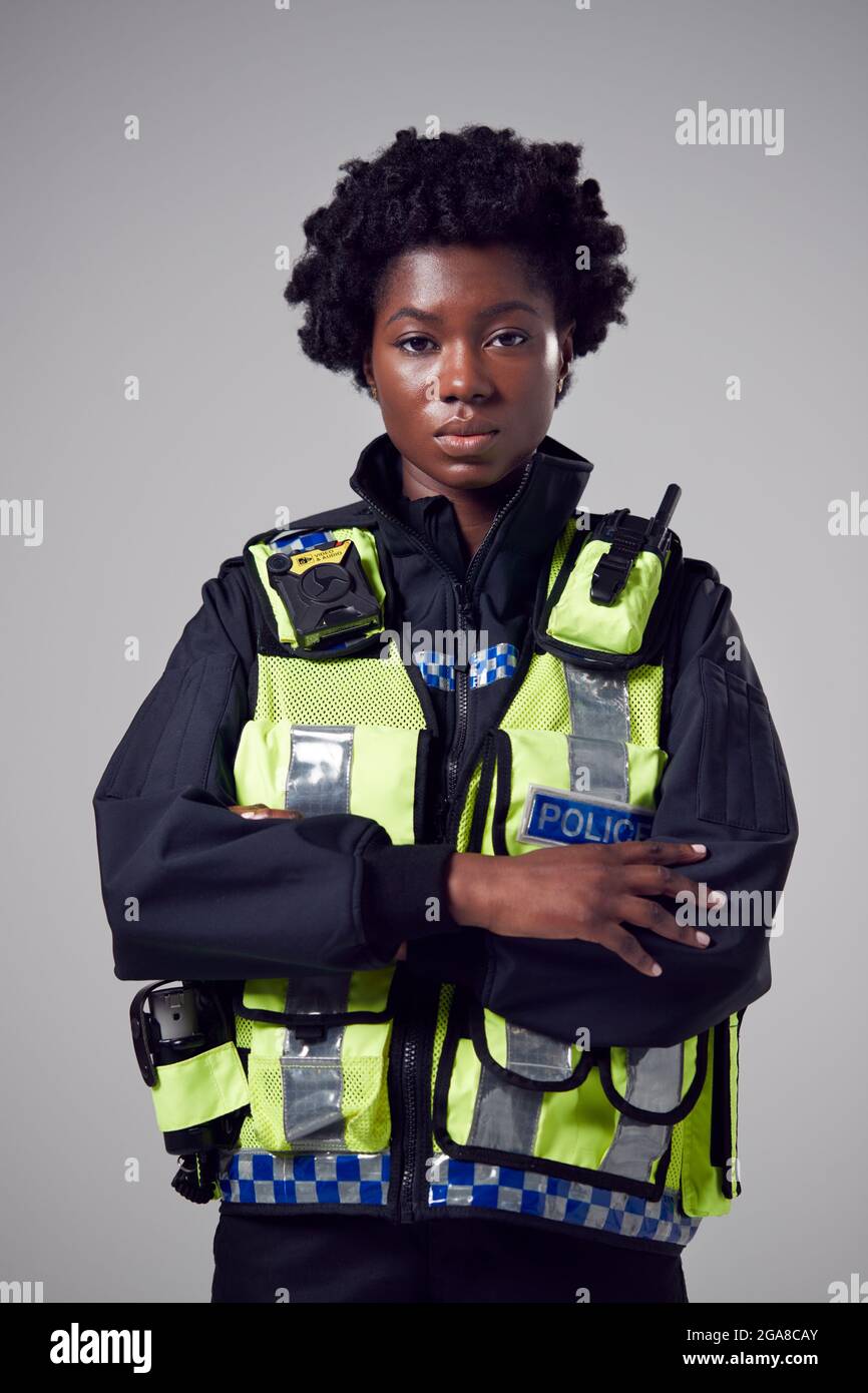 Studio Portrait Of Serious Young Female Police Officer Against Plain ...