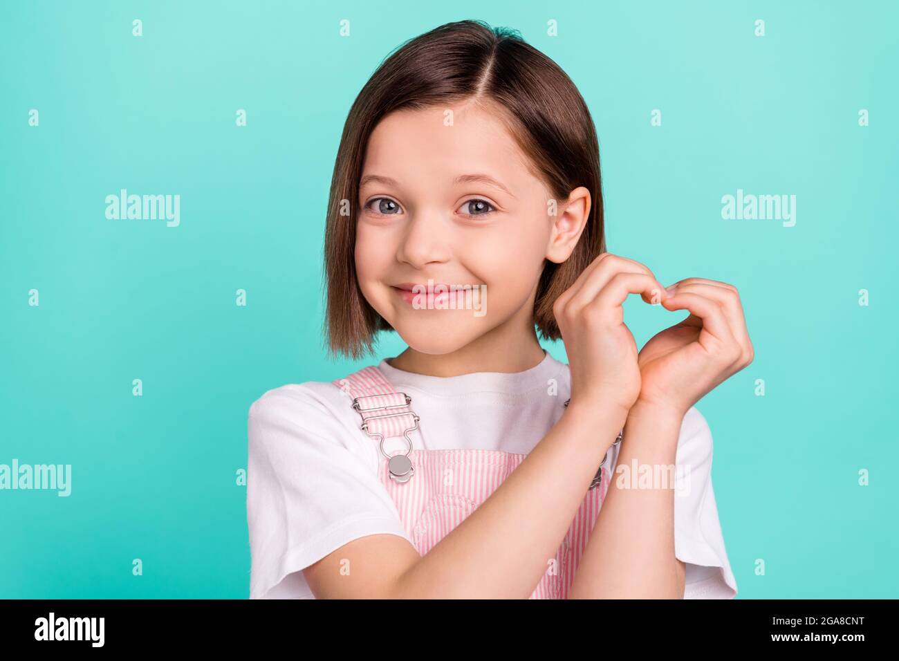 Photo of charming shiny school girl wear pink overall smiling showing ...