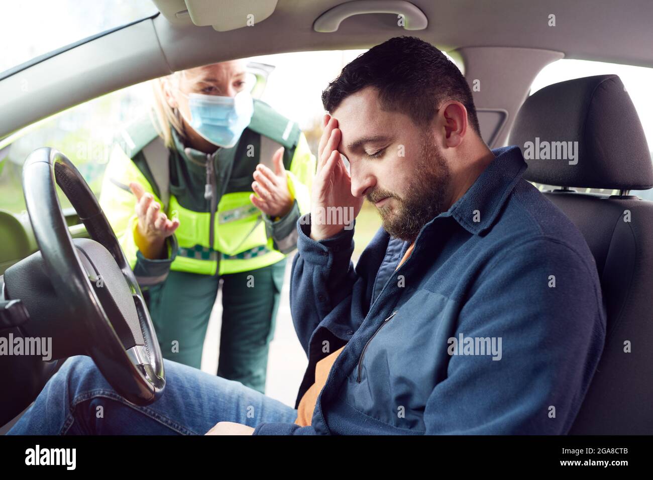 Female Paramedic Helping Male Driver With Whiplash Neck Injury Involved ...