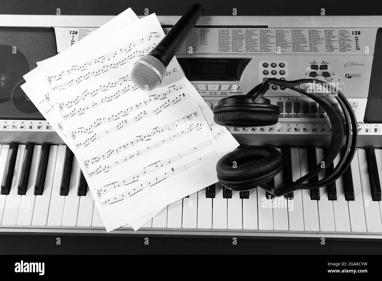 Headphones with music notes and microphone on synthesizer close up ...