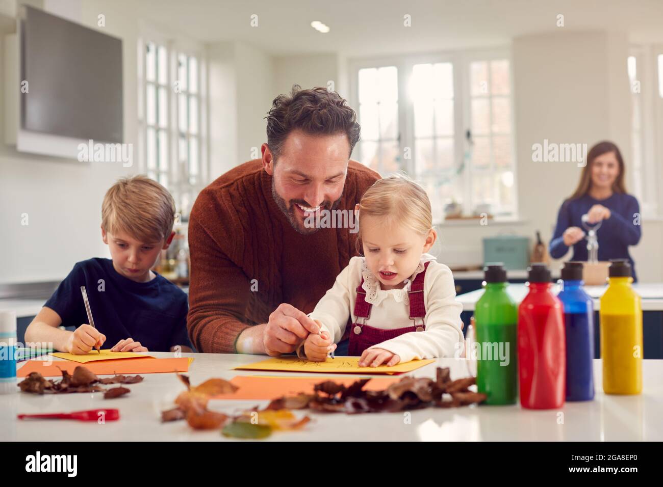 Father With Children At Home Doing Craft And Making Picture From Leaves ...