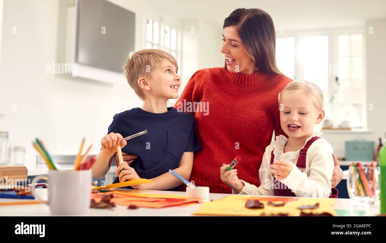 Mother With Children At Home Doing Craft And Making Picture From Leaves ...