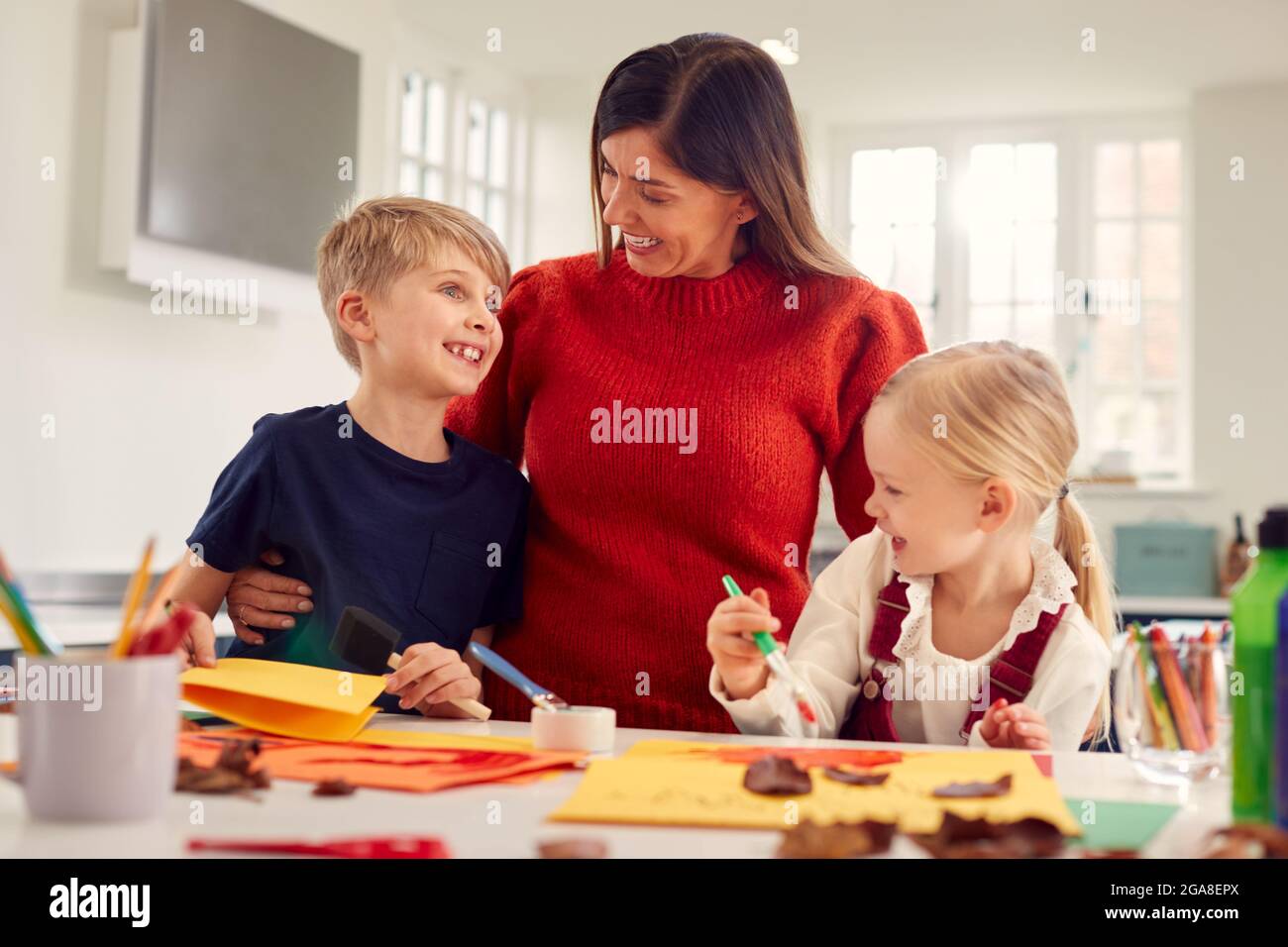 Mother With Children At Home Doing Craft And Making Picture From Leaves ...