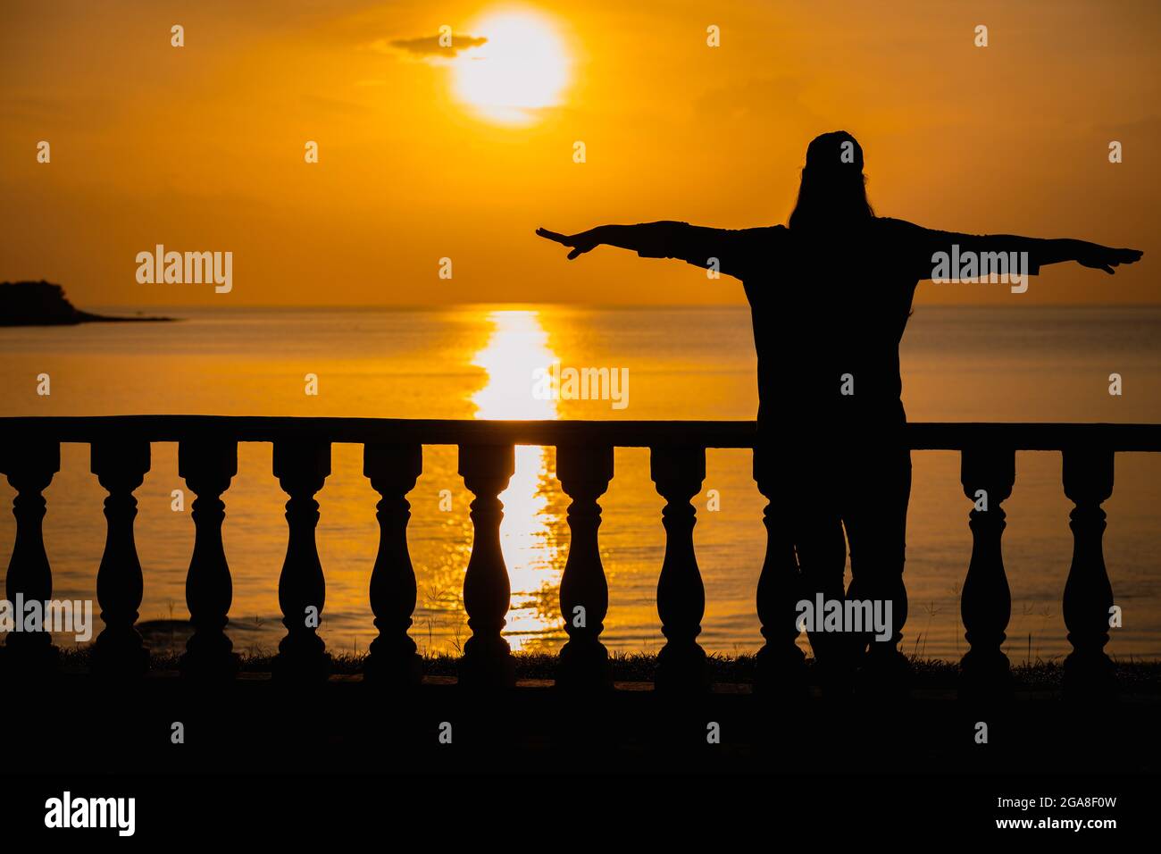 Silhouette Of A Woman Spreading Her Arms At Sunset On The Seashore