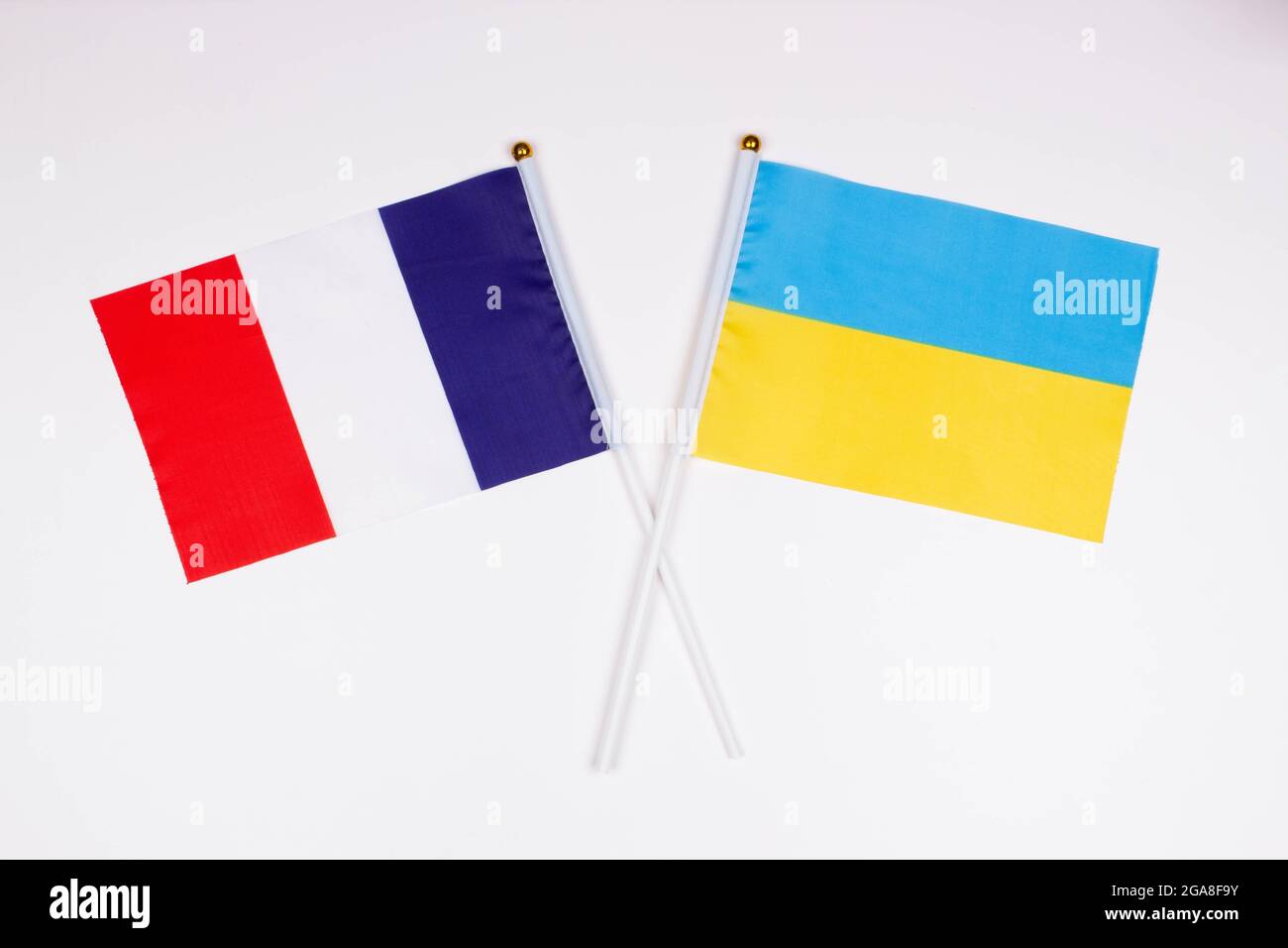 Flag of France and flag of Ukraine crossed with each other on a white ...