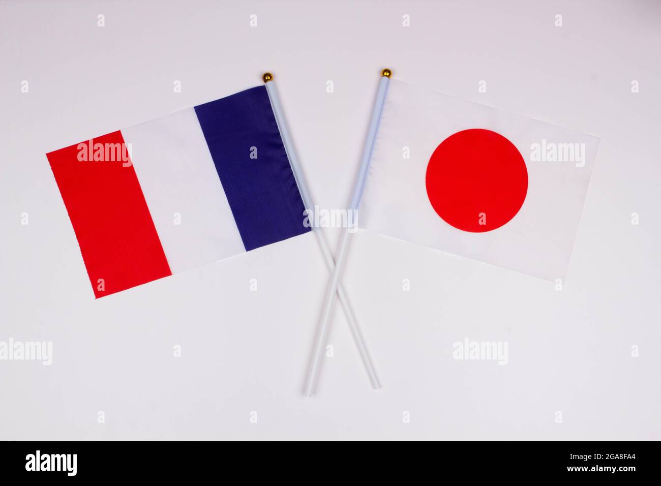 Flag of France and flag of Japan crossed with each other on a white ...