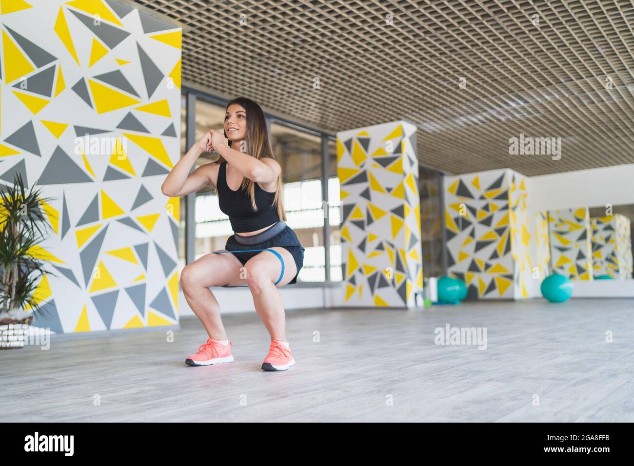 Shot of a sporty girl doing squats in the gym Stock Photo - Alamy