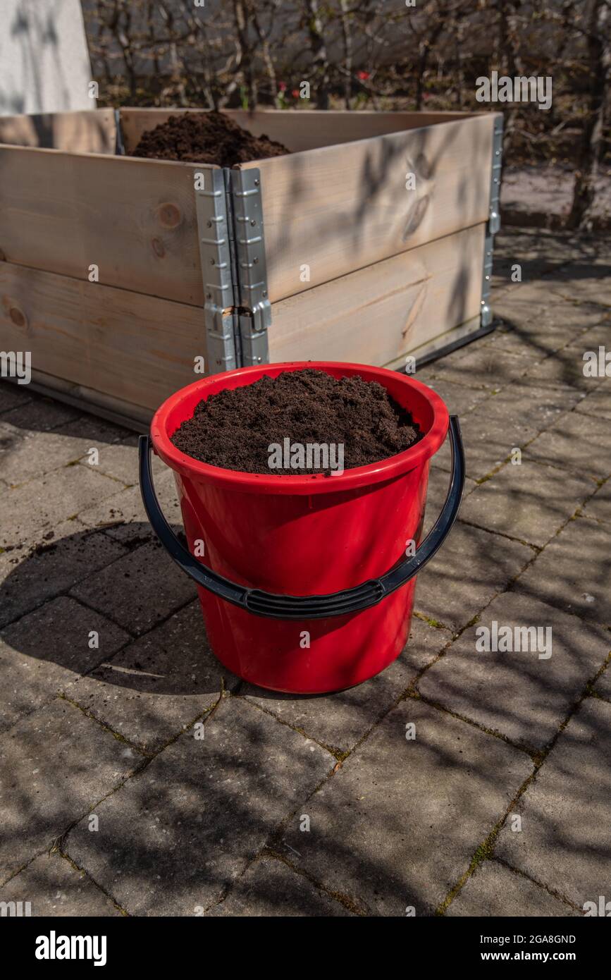 Fresh earth in a red bucket Stock Photo - Alamy