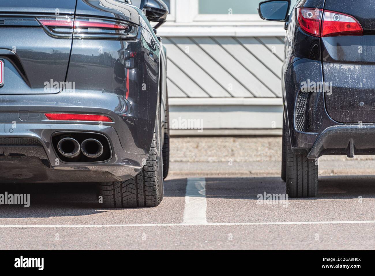Rear of two cars, one large and one tiny Stock Photo - Alamy