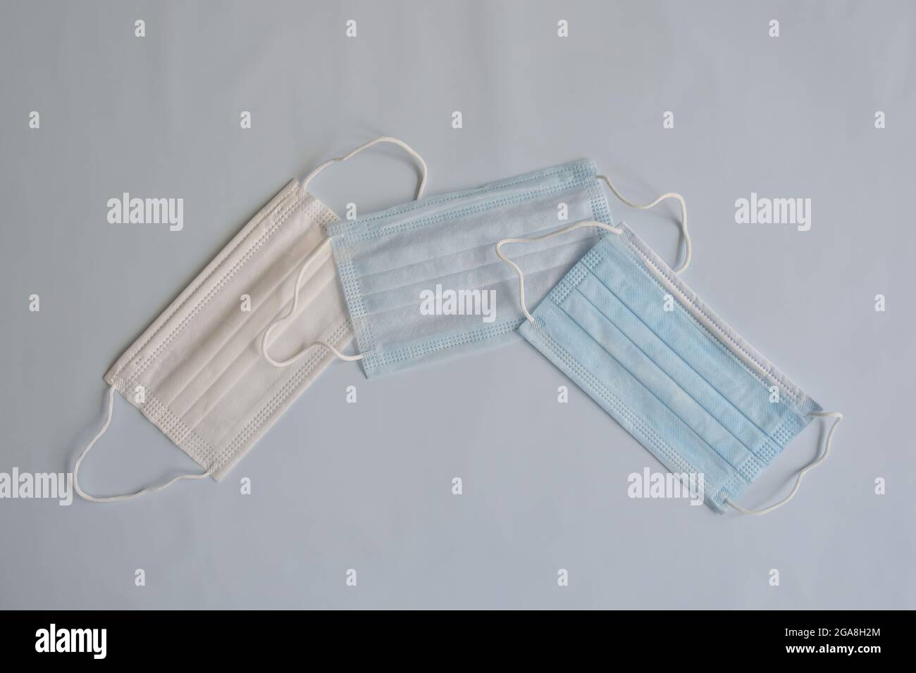 Three medical masks on light blue background. Virus protection remedies ...