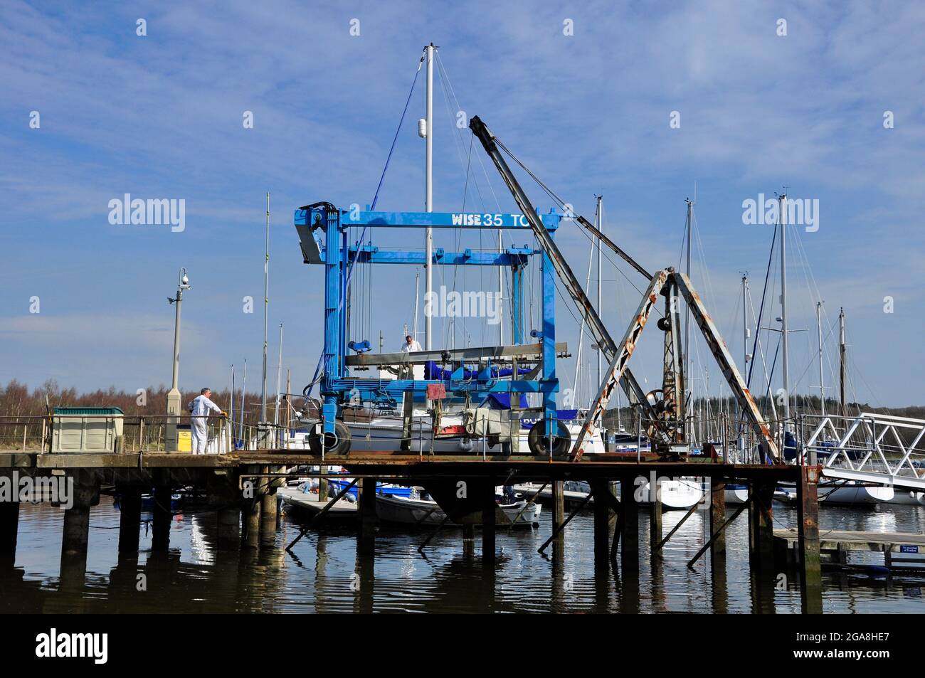 A yacht being raised out of the water by a boat lift at Bucklers Hard ...
