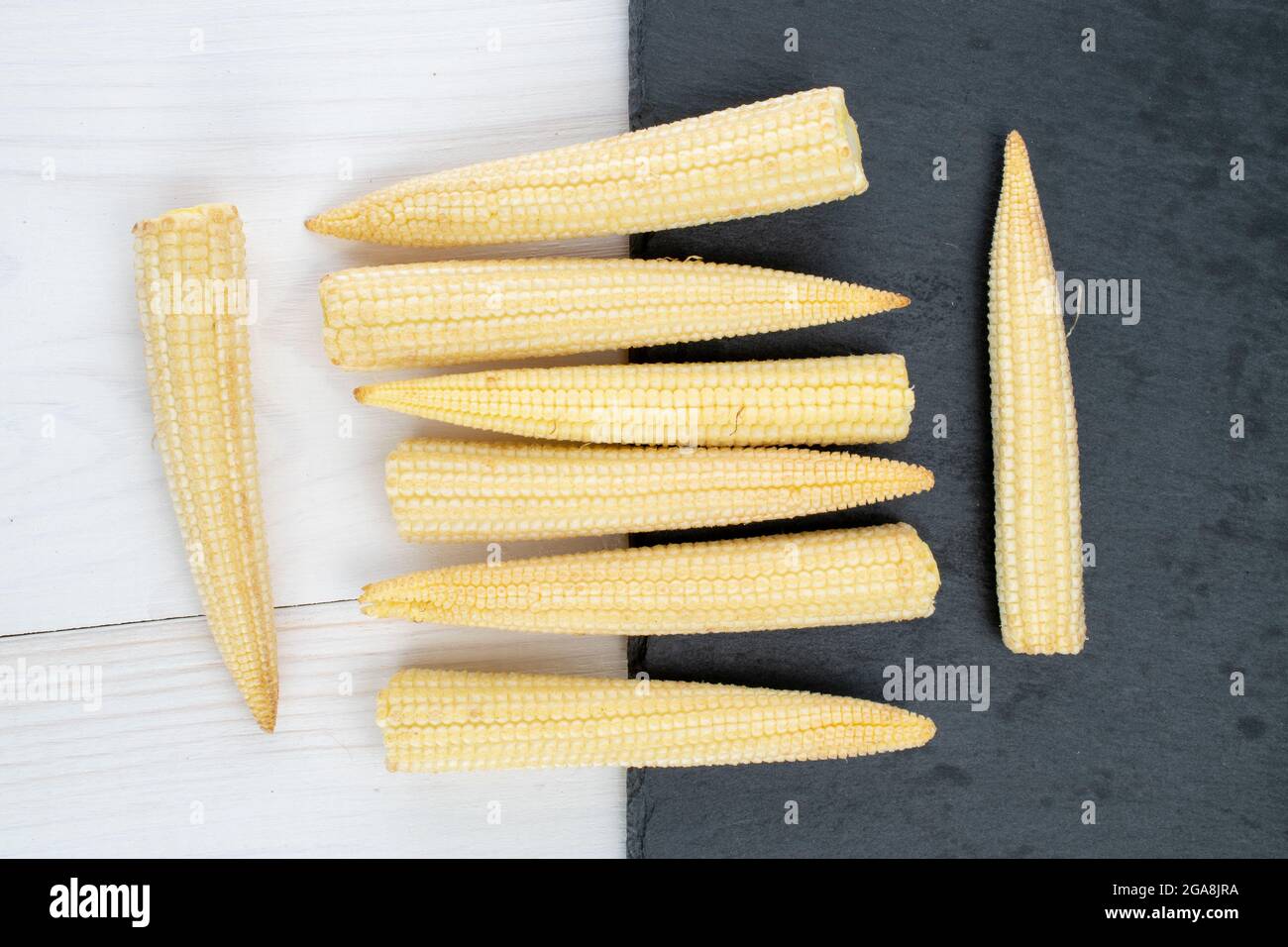 Somewhat bright yellow ripe sweet organic mini corn, close-up, against ...