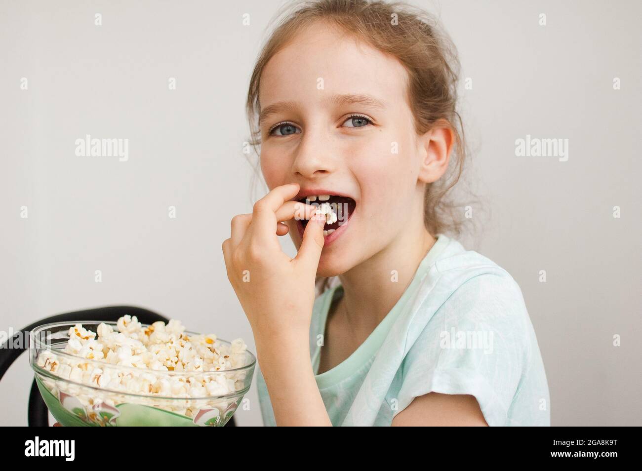 Portrait of a funny and excited schoolgirl girl on a white background ...