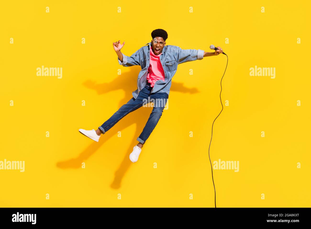 Full size photo of happy afro american young man jump up singer enjoy ...