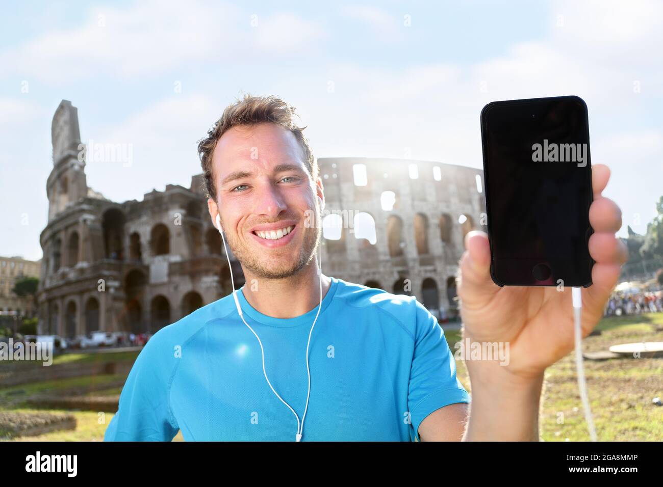 Smiling Jogger Showing Smartphone Against Colosseum Stock Photo - Alamy