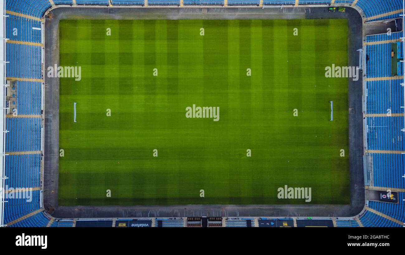 Aerial photo of stadium pitch without lines. Surrounded by blue seats ...