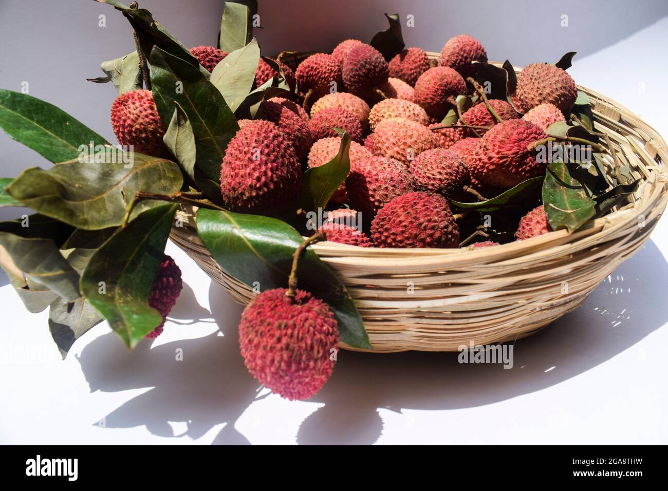 Side view of fresh plucked Lychees fruit in wicker bamboo basket ...