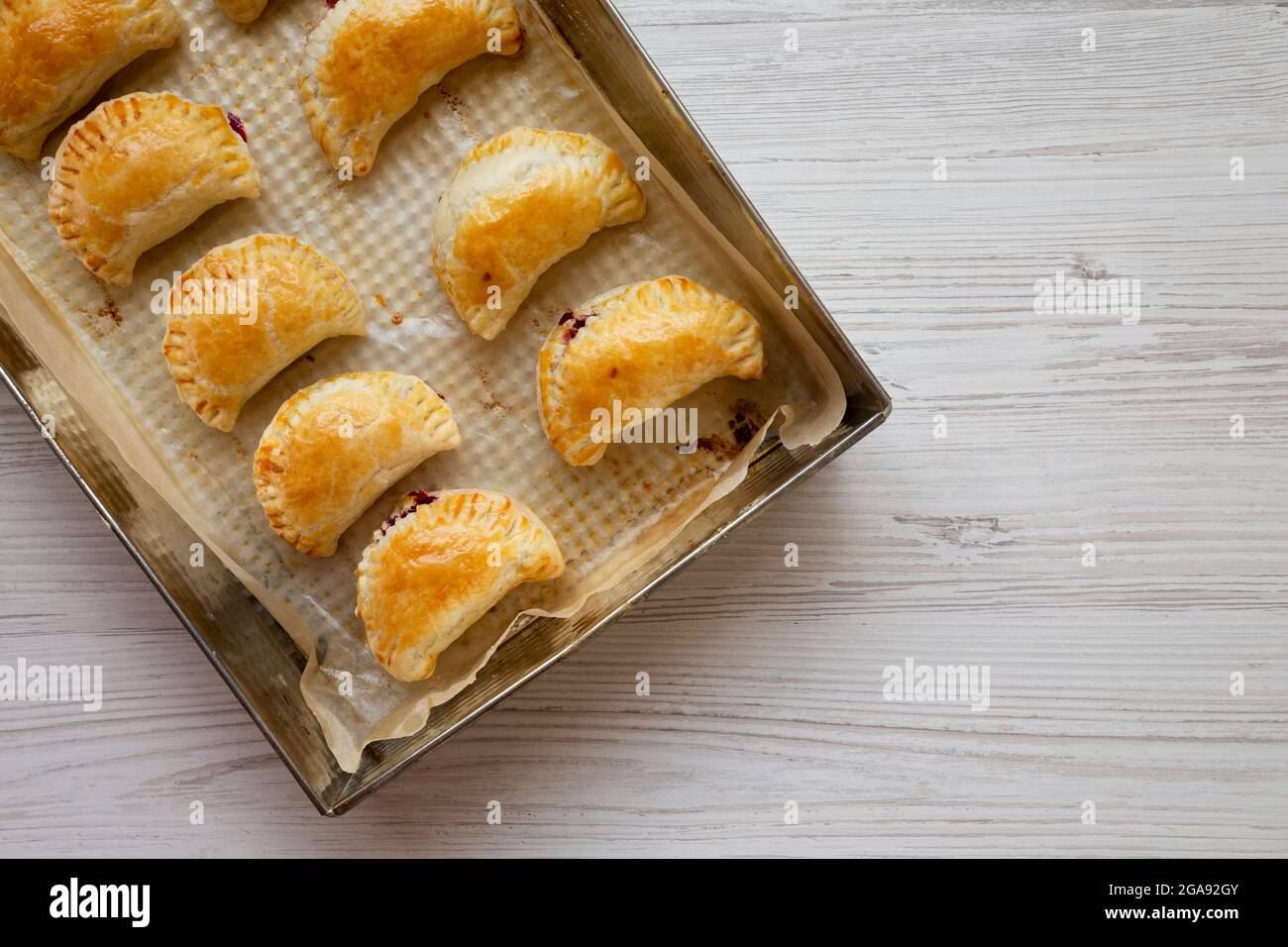 Homemade Cherry Hand Pies in a baking pan, top view. Flat lay, overhead ...