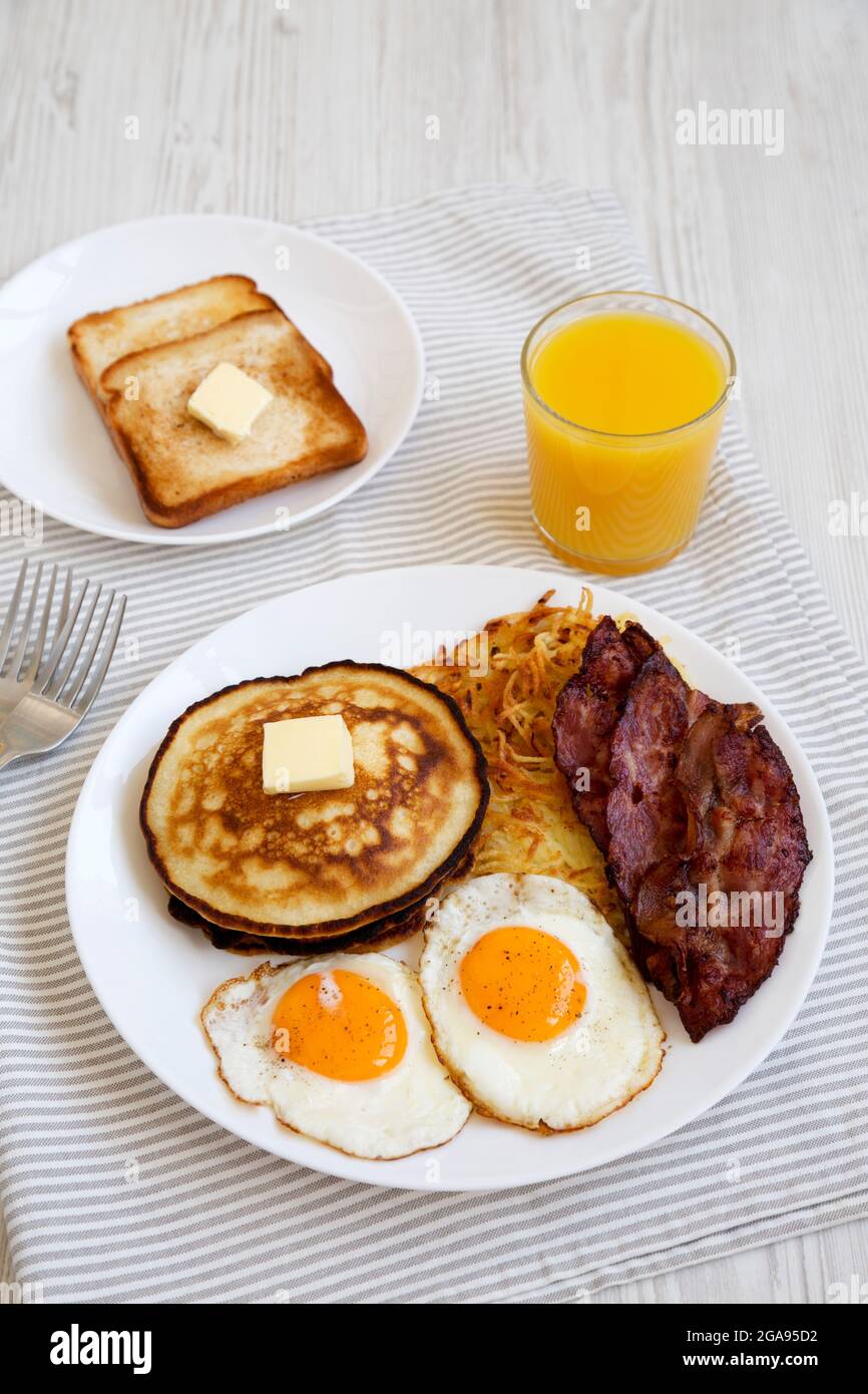 Full American Breakfast with Bacon, Hash Browns, Eggs and Pancakes on a ...