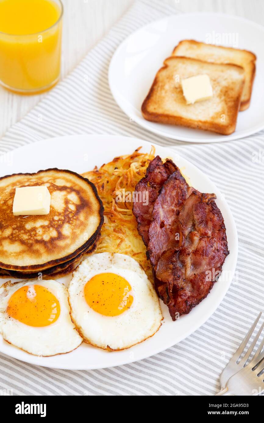 Full American Breakfast with Bacon, Hash Browns, Eggs and Pancakes on a ...