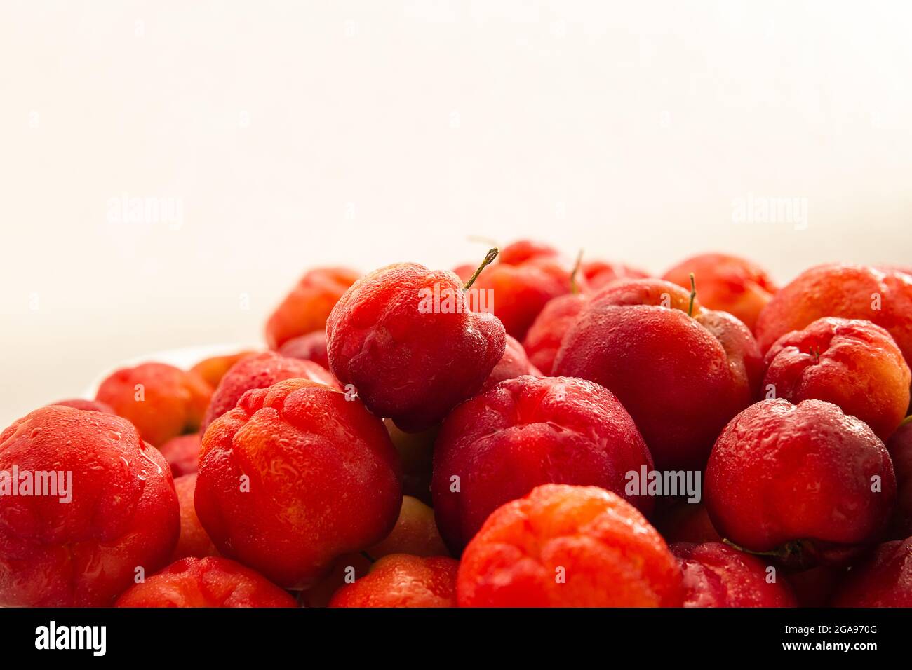 Pile of ripe acerolas wet from being chilled Stock Photo - Alamy