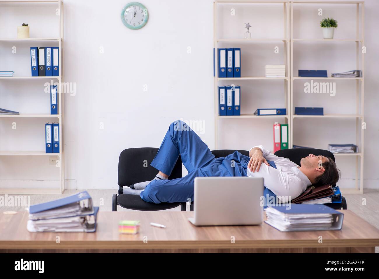 Young employee sleeping in the office on chairs Stock Photo - Alamy