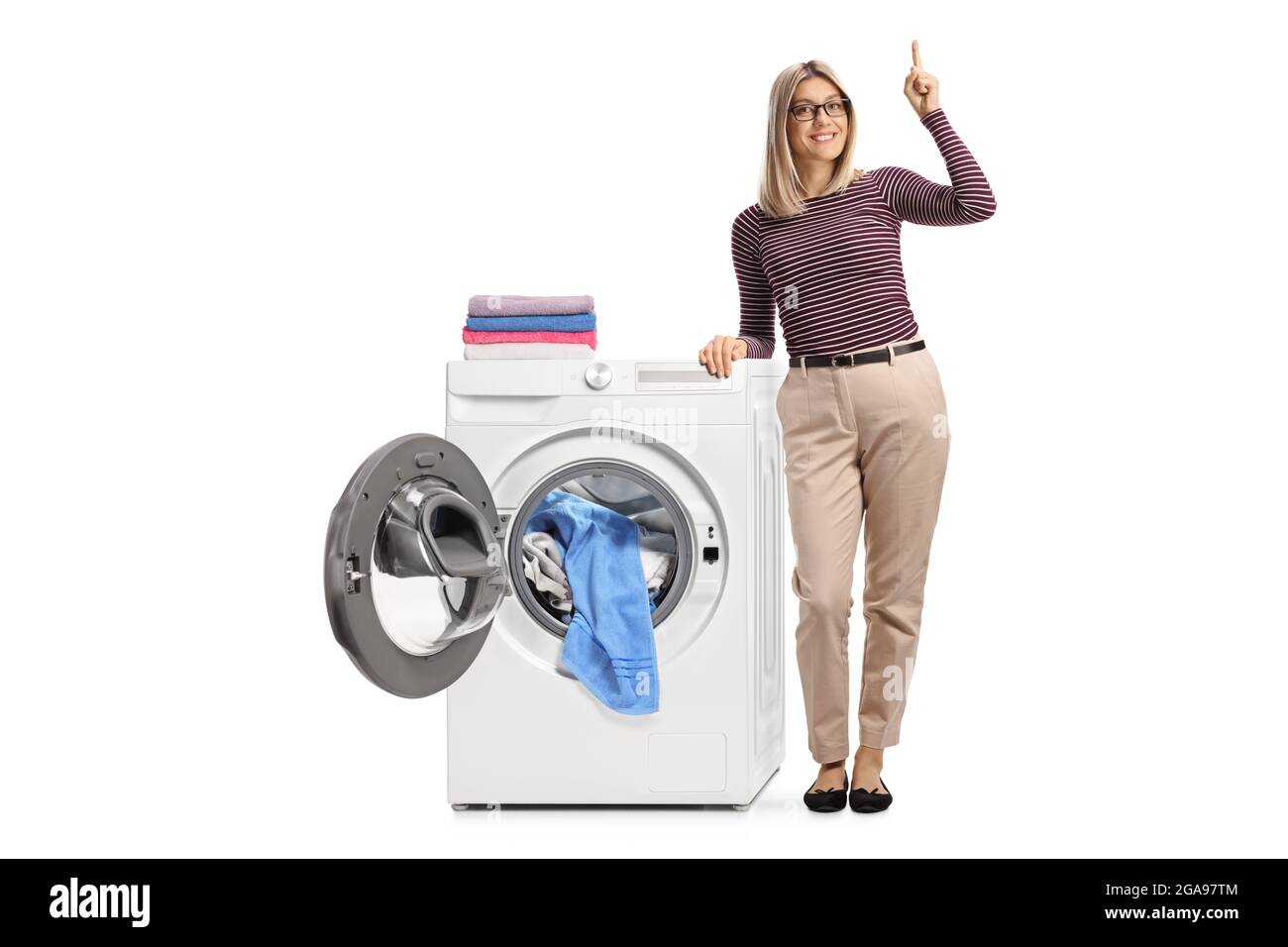 Full length portrait of a young woman leaning on a washing machine with ...