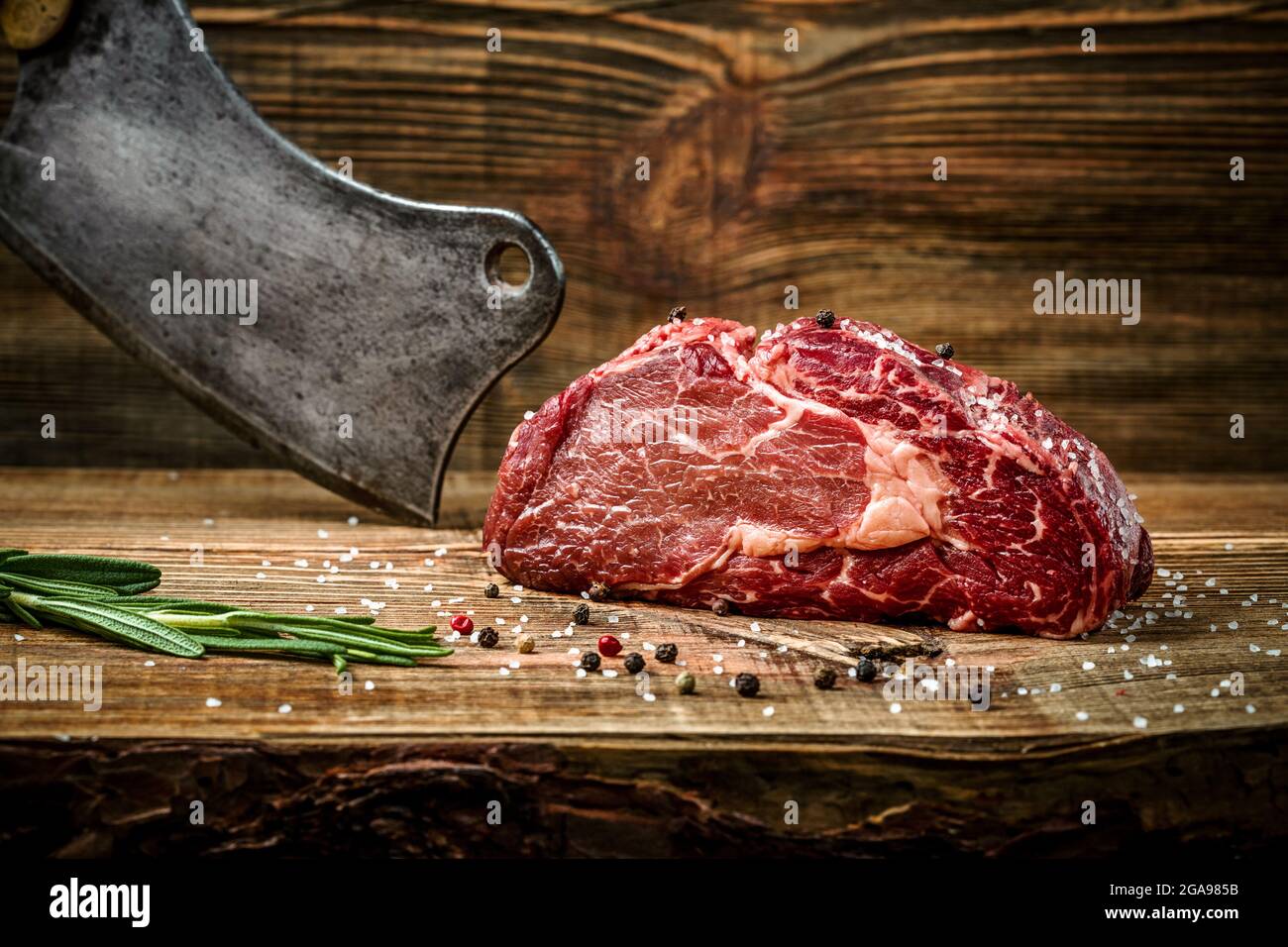 Dry aged Ribeye Steak with seasoning on wooden background Stock Photo ...