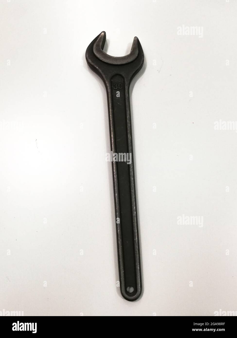 Vertical shot of a black wrench on an isolated background - concept of ...