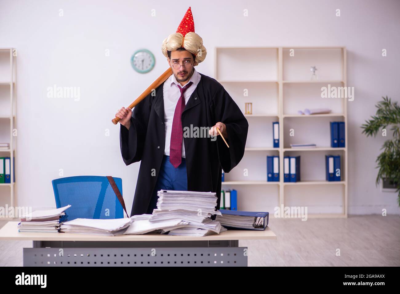 Funny young employee magician and too much work in the office Stock ...