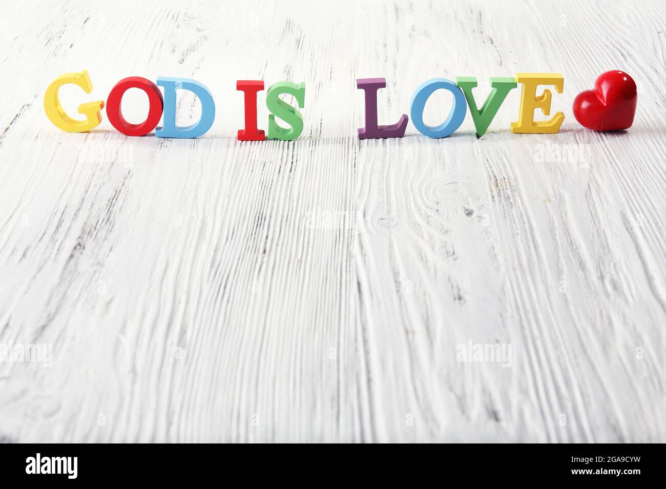 GOD IS LOVE sign illustrated with colorful plastic letters on white ...