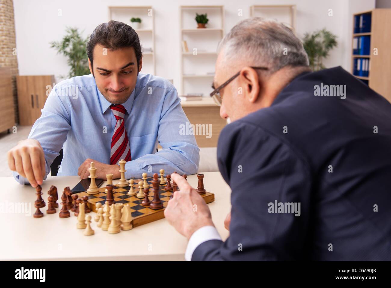 Two male employees playing chess at workplace Stock Photo - Alamy