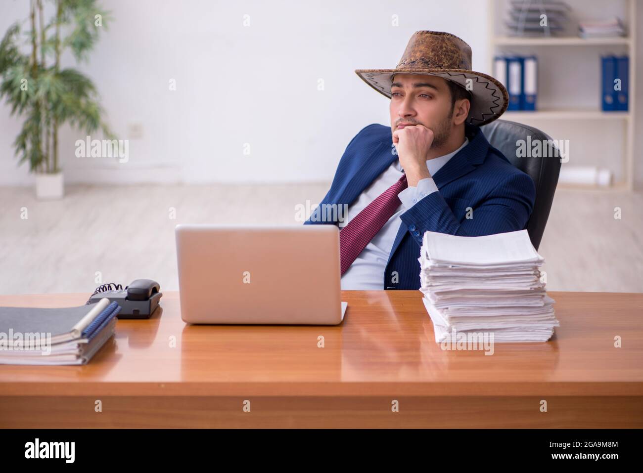 Young cowboy employee working at workplace Stock Photo - Alamy
