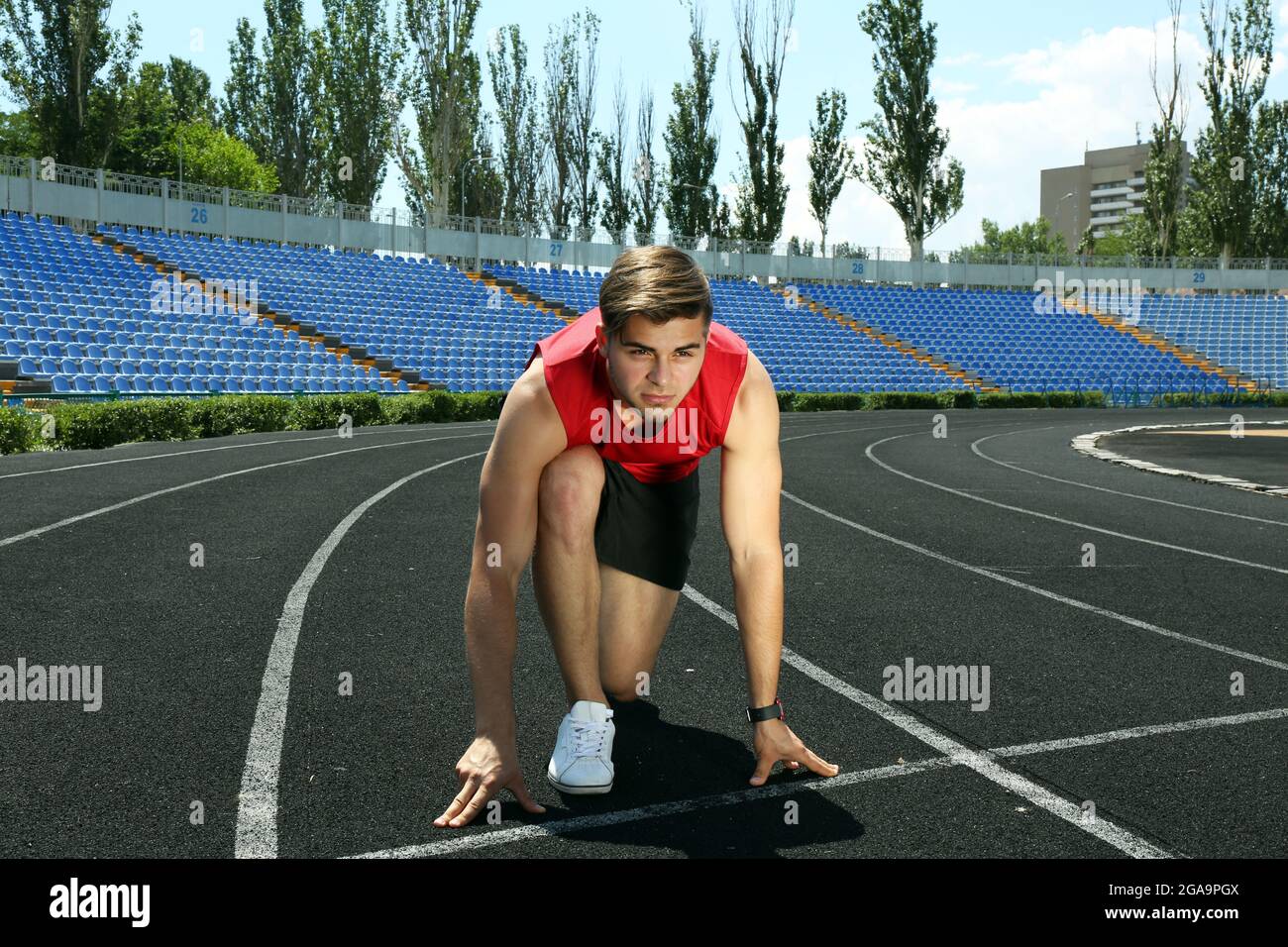 Runner in start position on stadium Stock Photo - Alamy