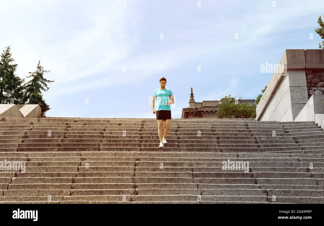 Young man jogging at stairs outdoors Stock Photo - Alamy