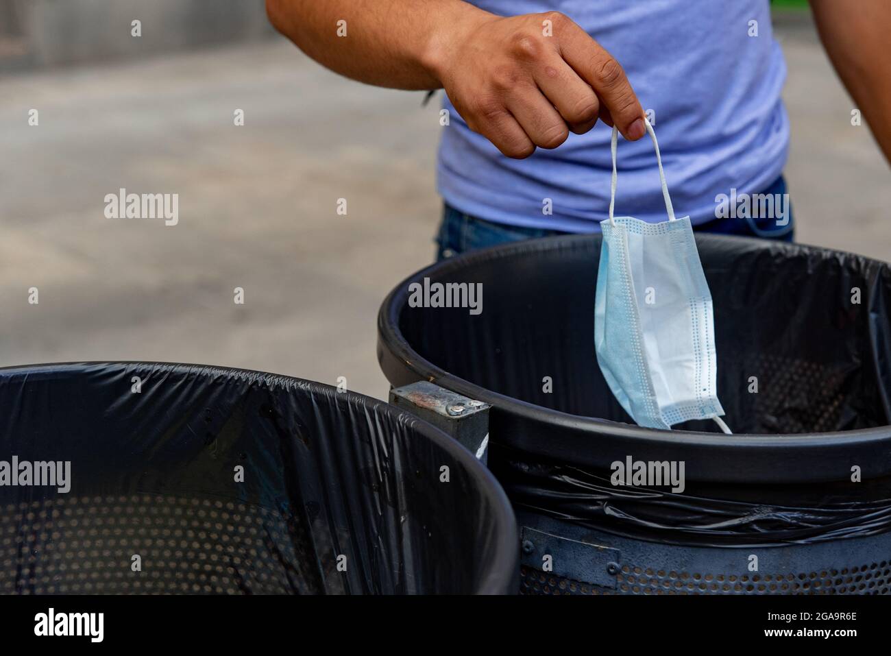 human hand throwing face mask into trash Stock Photo - Alamy