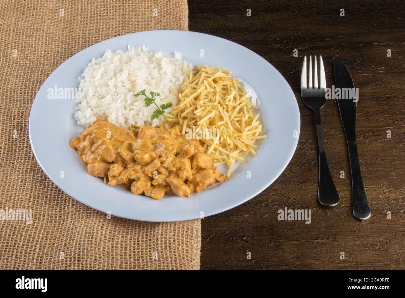 Food dish with chicken stroganoff and rice and chips Stock Photo - Alamy
